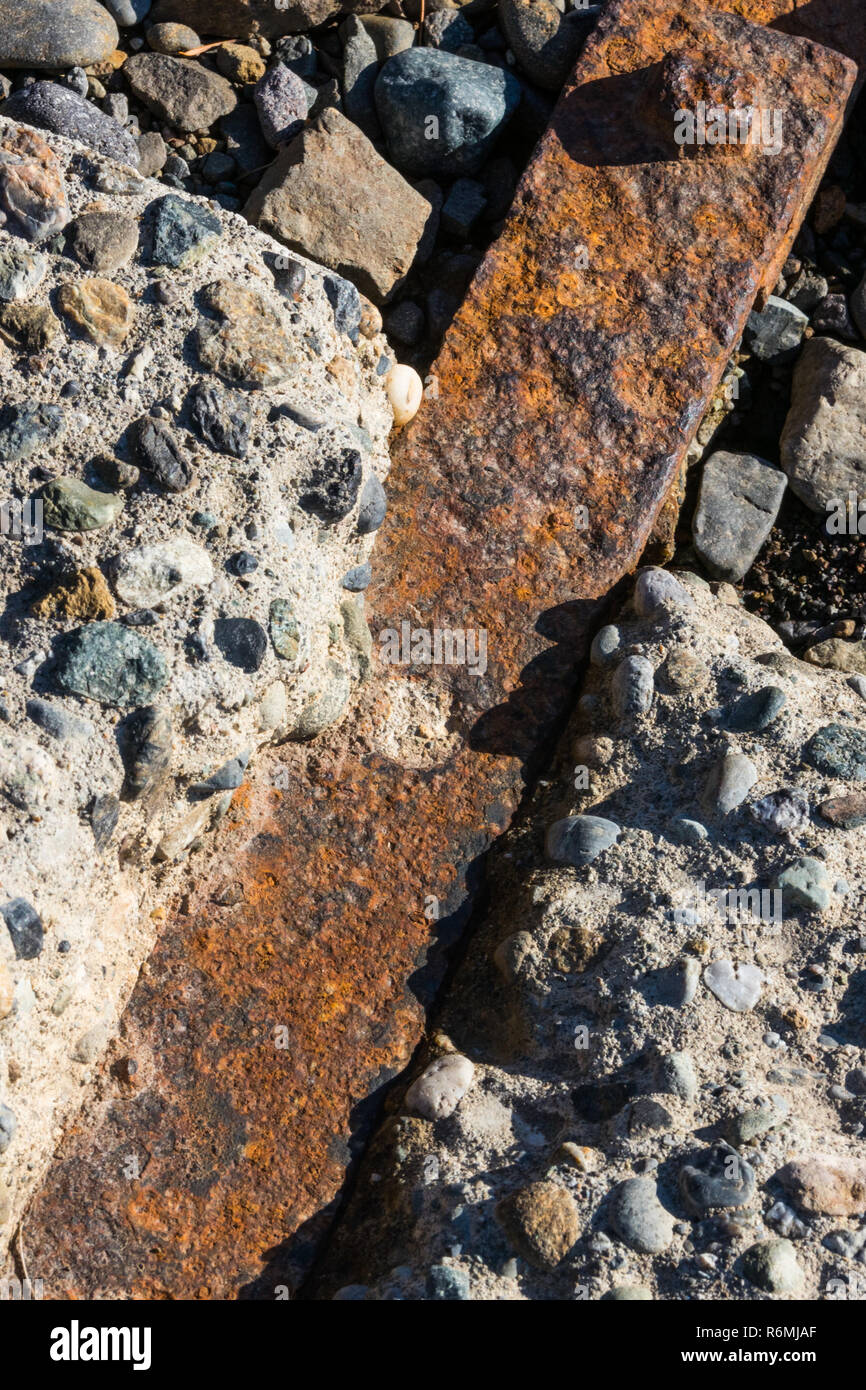 Rusty iron bar impregnated between rocky concrete blocks Stock Photo ...