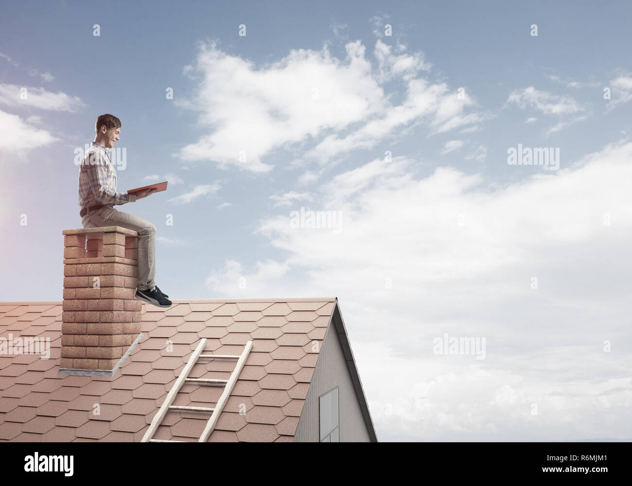 Handsome man on brick roof against cloud scape reading book Stock Photo ...