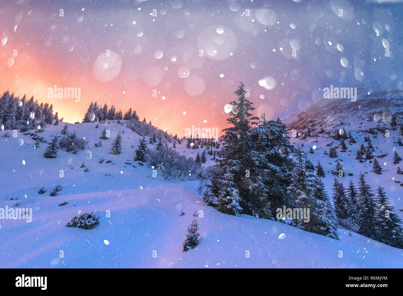 Fantastic orange winter landscape in snowy mountains glowing by sunlight. Dramatic wintry scene ...