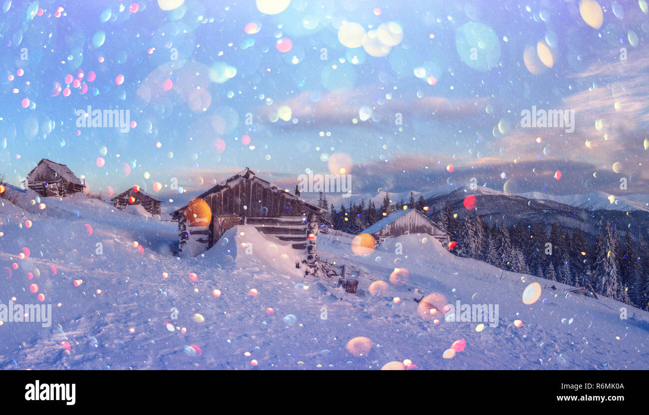 Fantastic winter landscape with wooden house in snowy mountains. Christmas holiday postcard ...
