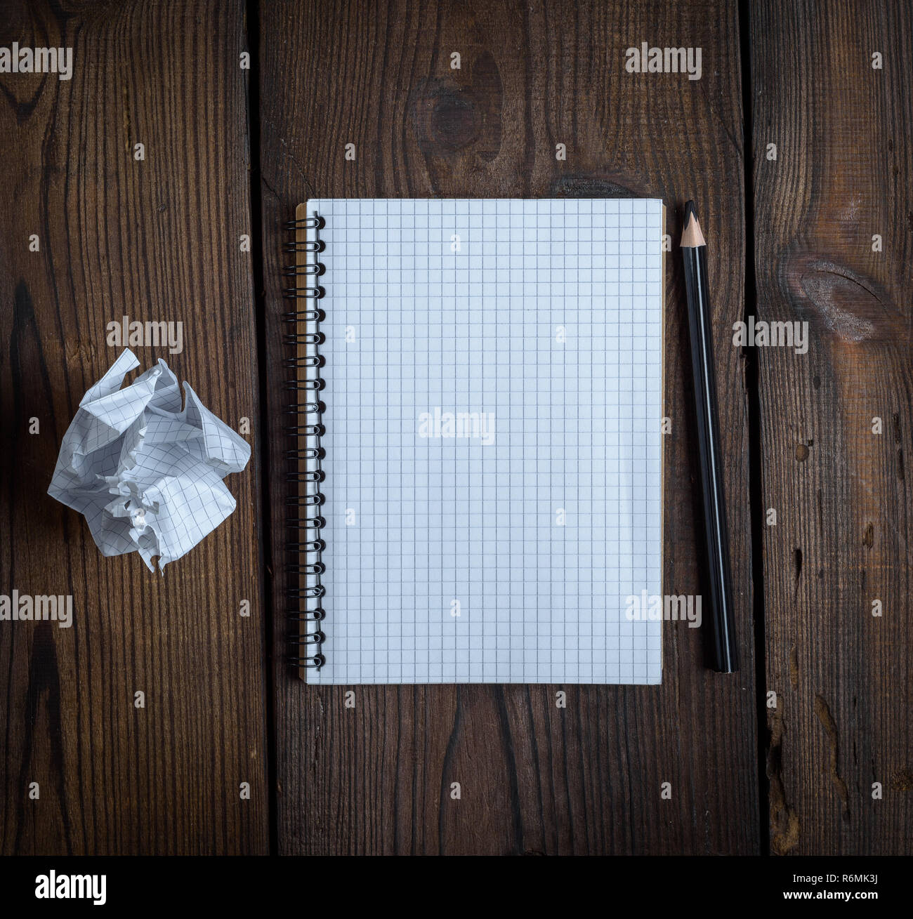 open notebook with white sheets and a crumpled ripped out sheet of ...