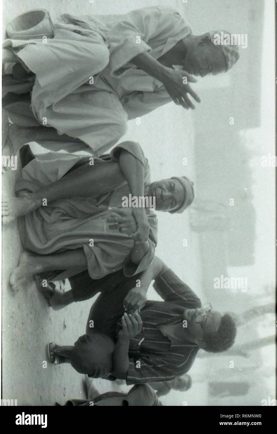 A group of men sitting down - talking to each other Stock Photo - Alamy