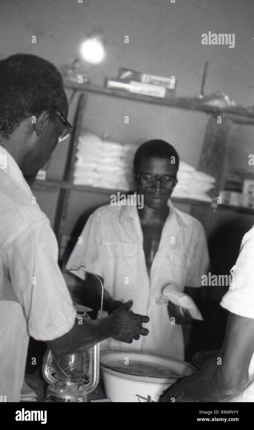 Group of men observing objects in a bowl Stock Photo - Alamy