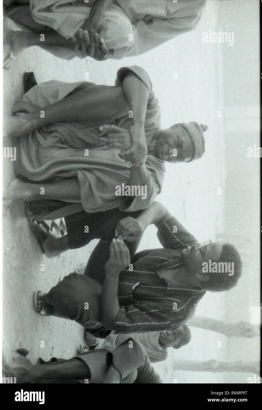 A group of men sitting down - talking to each other Stock Photo - Alamy