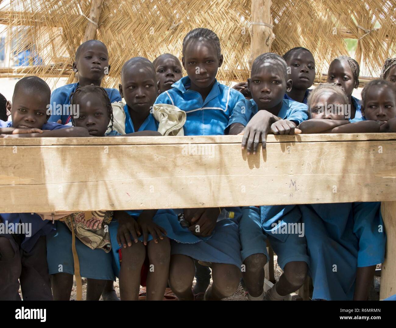 Students share a desk while attending a school in northern Cameroon ...