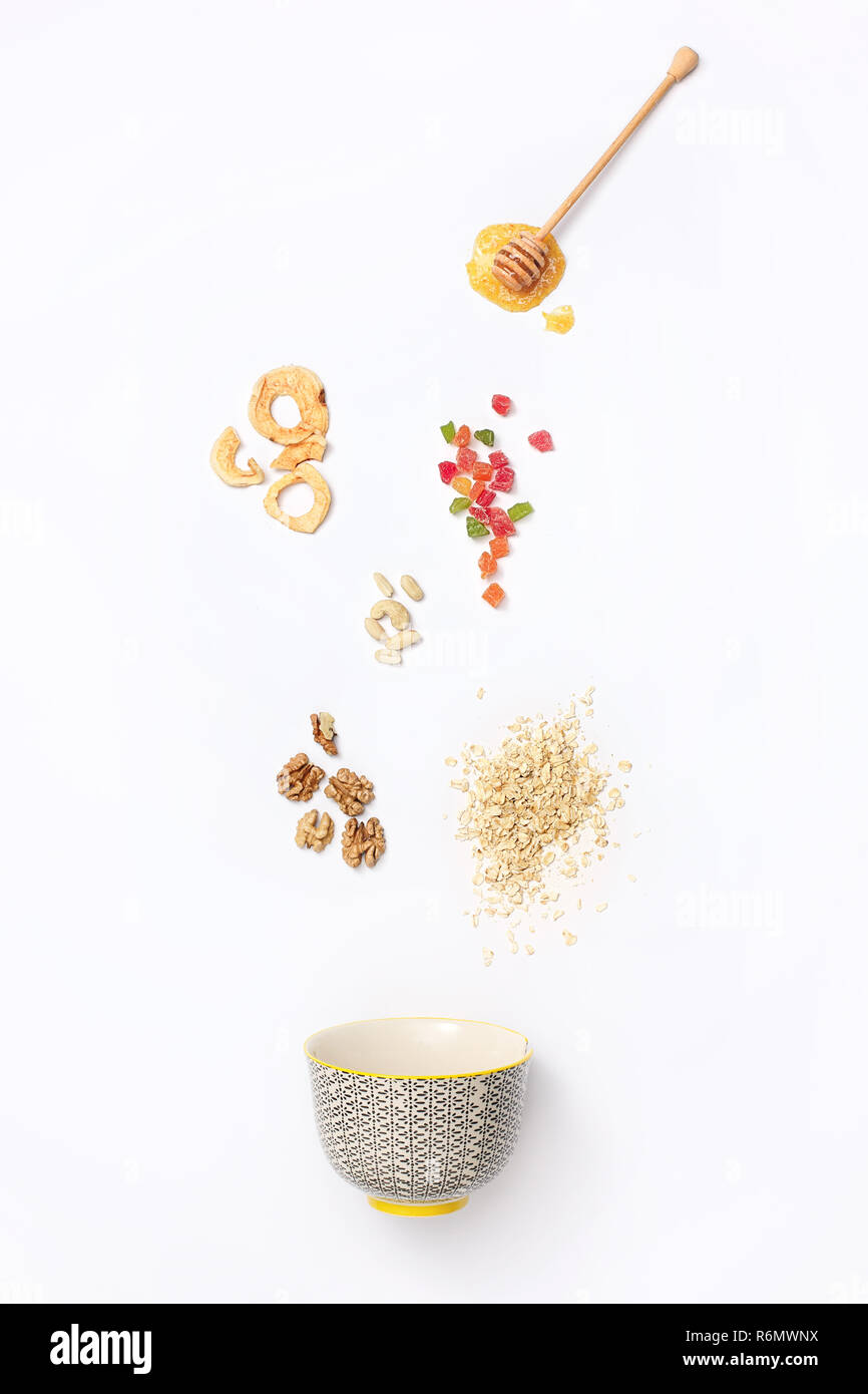 Falling granola with falling blueberries and honey flows from dipper ...