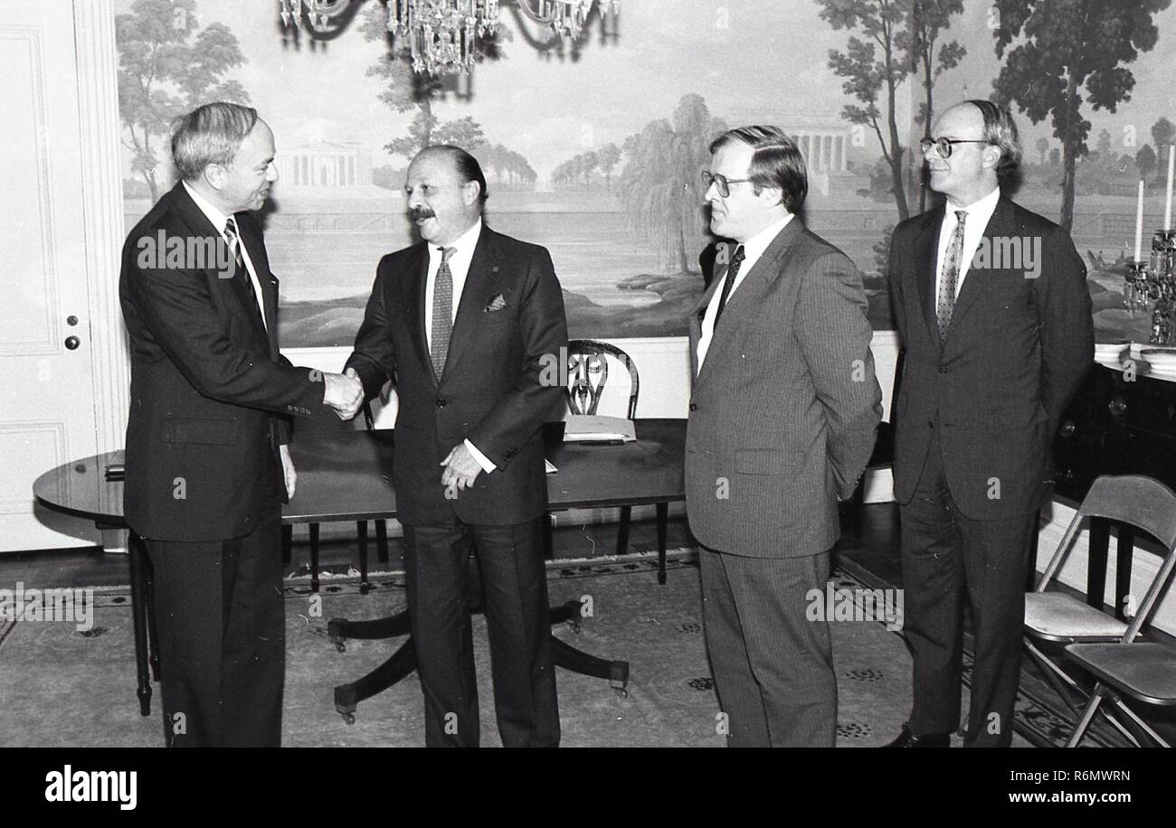 FOUR MEN ARE HAVING A CONVERSATION AND A HAND SHACK Stock Photo - Alamy