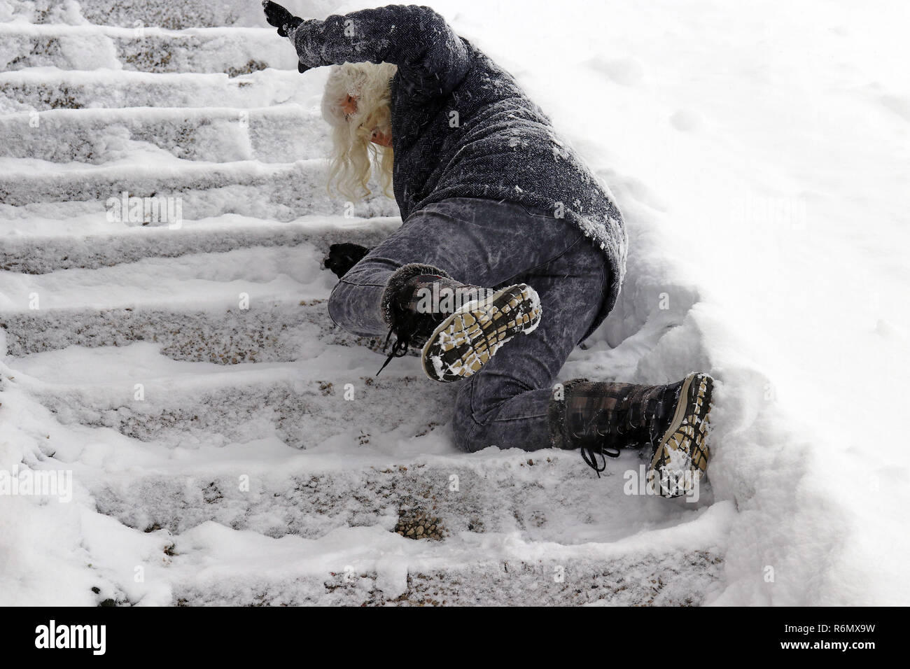 a woman slipped on a wintry staircase and fell down. fall on smooth ...