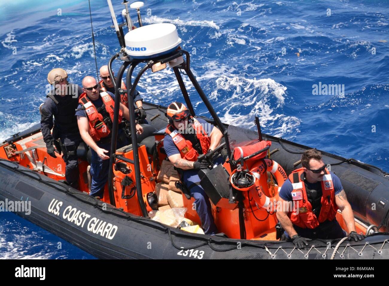 A Coast Guard Cutter Diligence pursuit team works to interdict a "go ...
