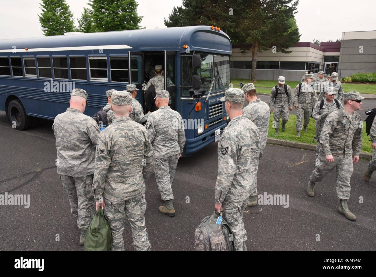 Airmen from the 142nd Fighter Wing prepare to load up on buses to ...
