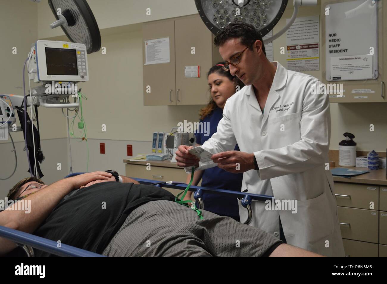 Army Capt. (Dr.) Clayton Lewis, general surgery, looks at the tag ...