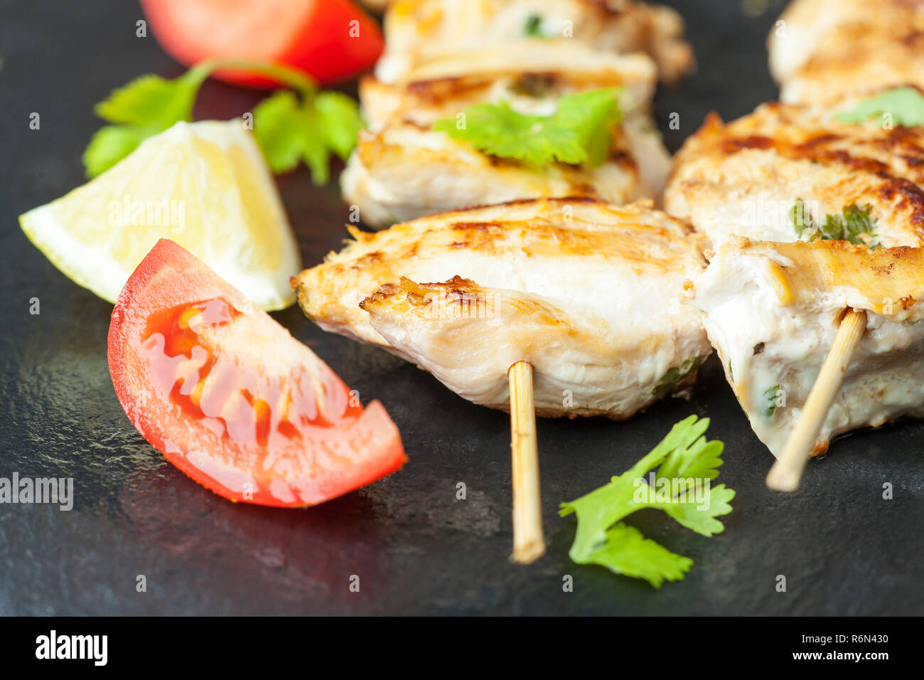 grilled chicken spit with cilantro Stock Photo - Alamy