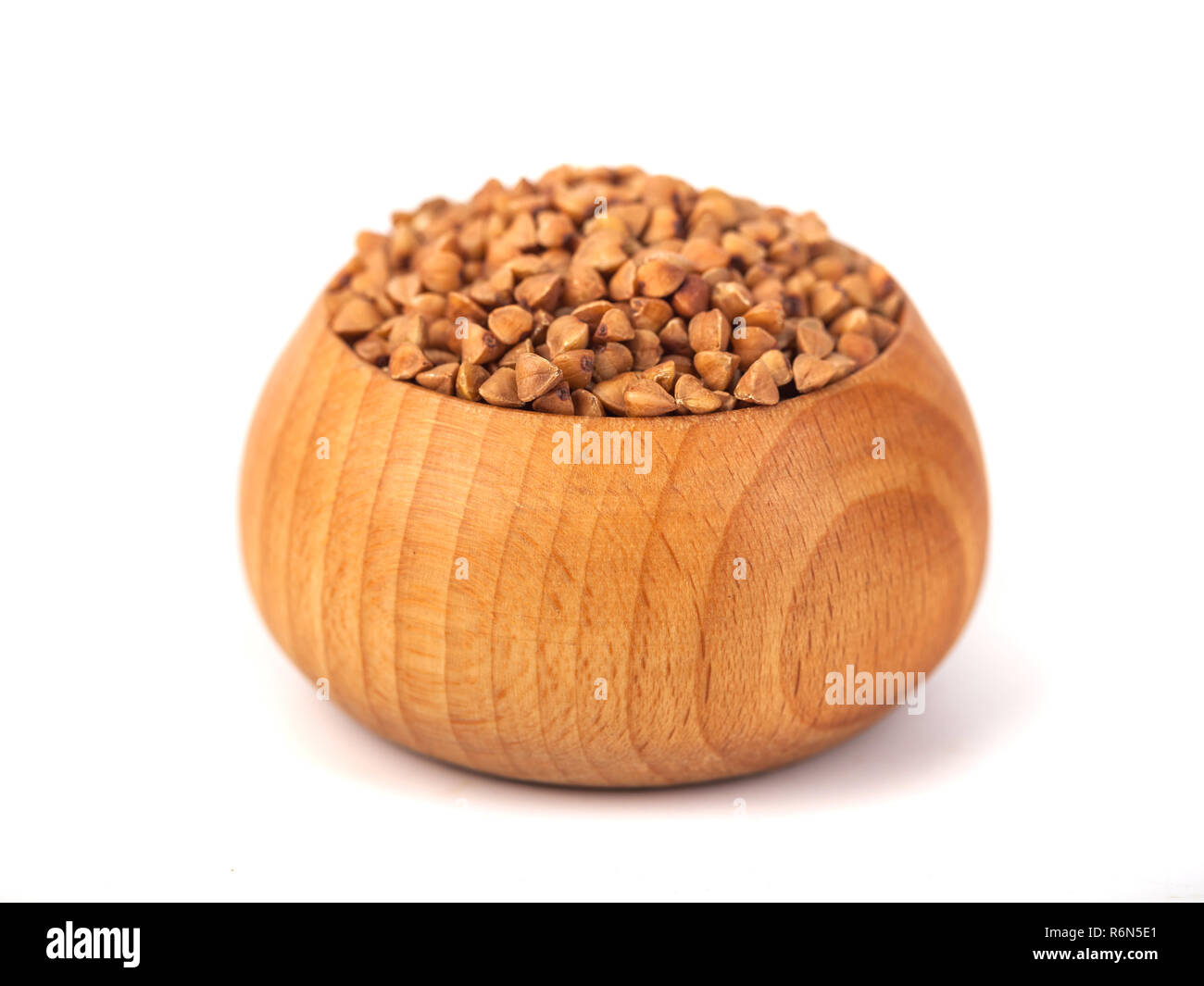 Roasted buckwheat grains in wooden bowl isolated on white background ...