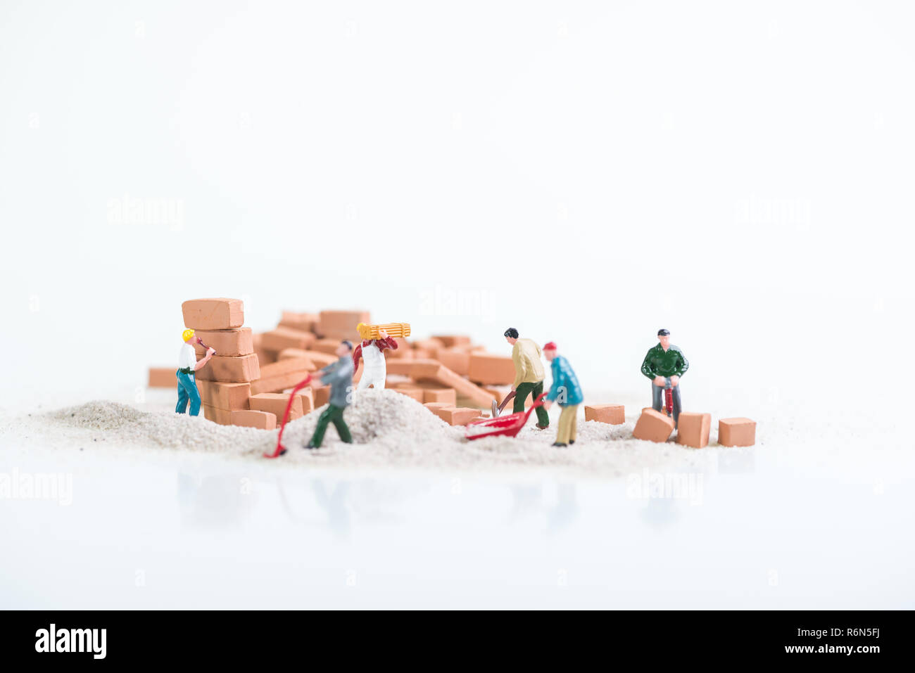 Miniature workmen doing construction work Stock Photo - Alamy