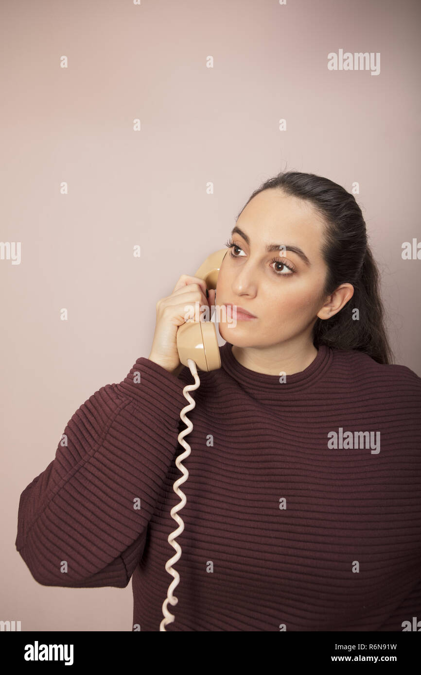 Young woman listening to a telephone call Stock Photo - Alamy
