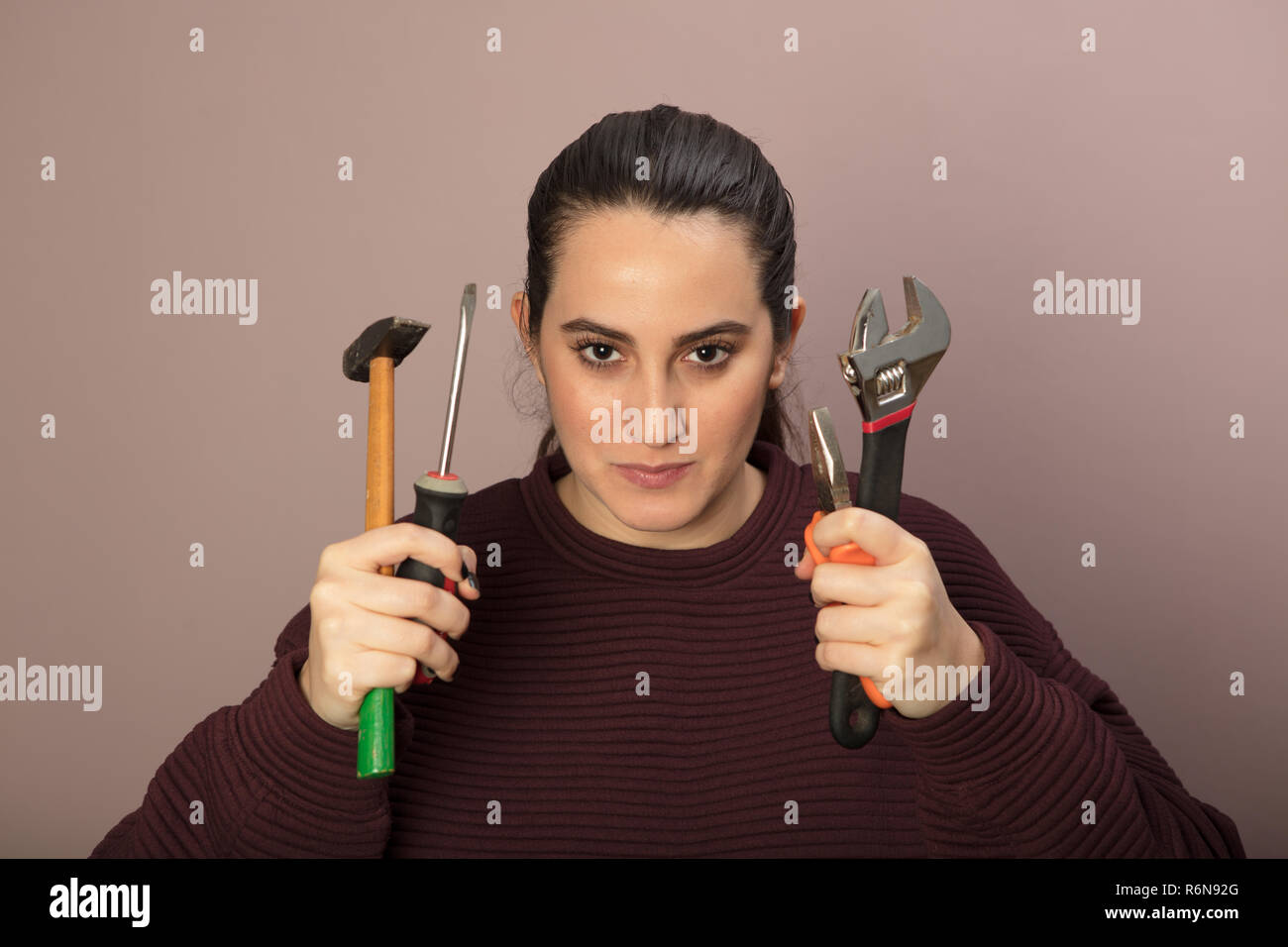 Capable young woman holding a set of tools Stock Photo - Alamy