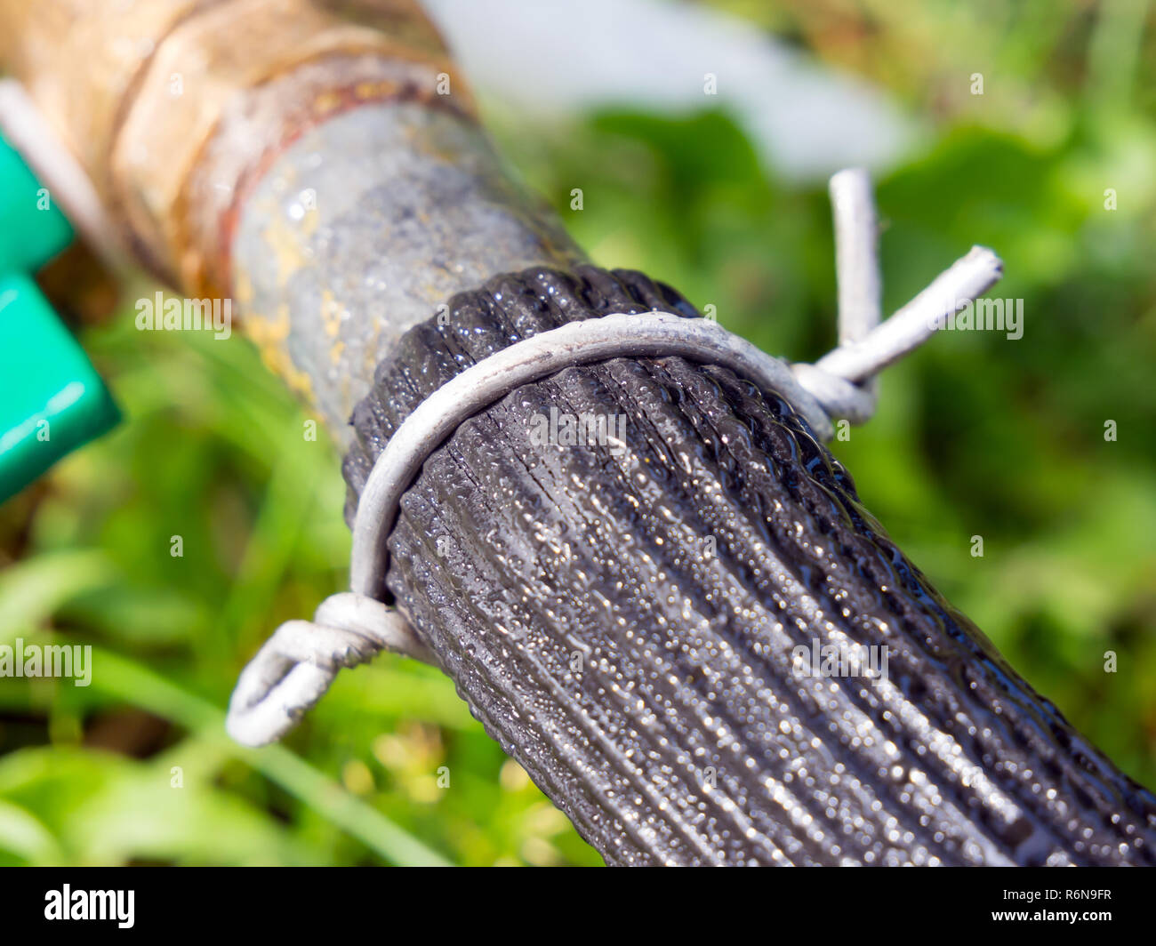 Fastening the hose to the pipe with a wire clamp Stock Photo - Alamy