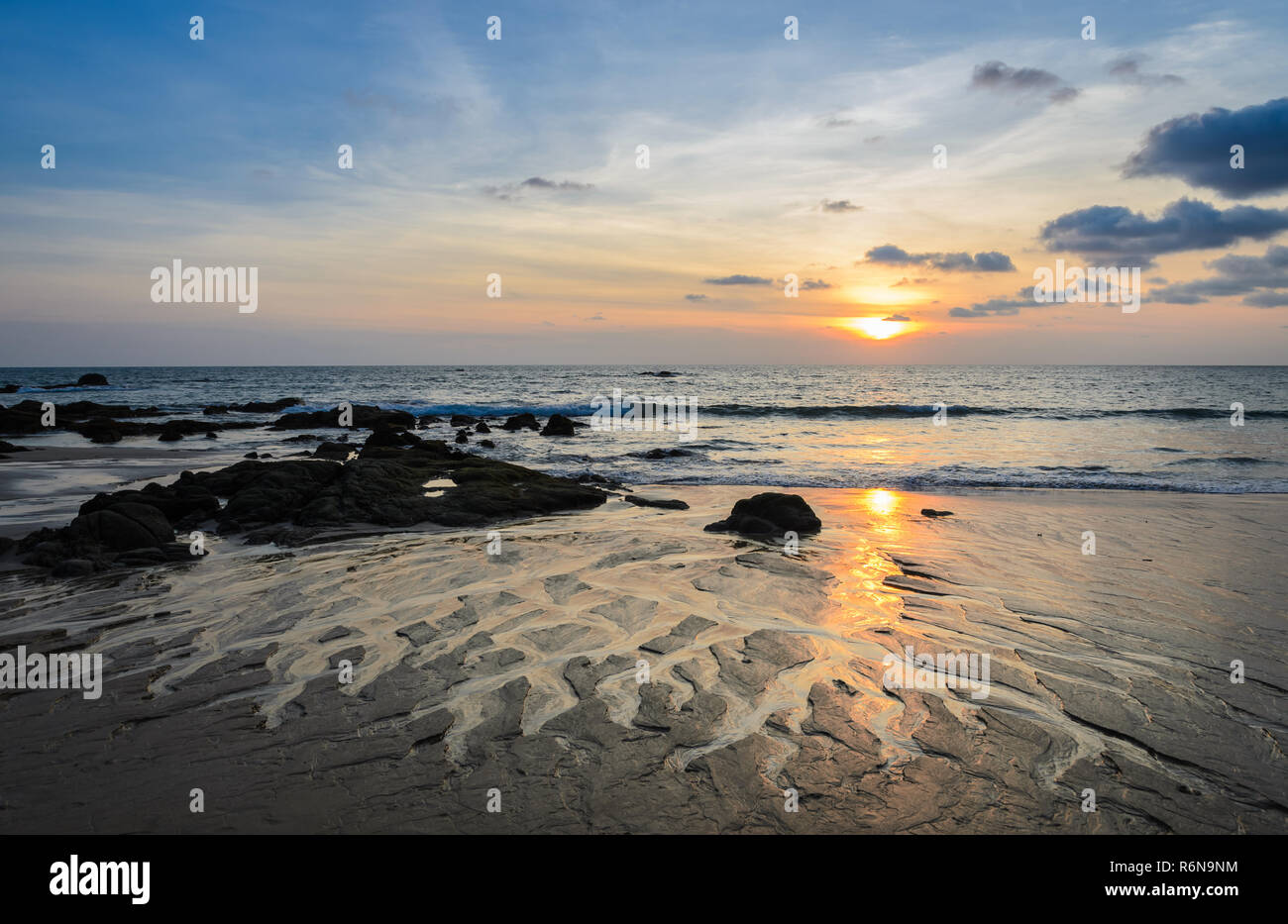 Rock beach sunset with beautiful cloudscape skyline Stock Photo - Alamy