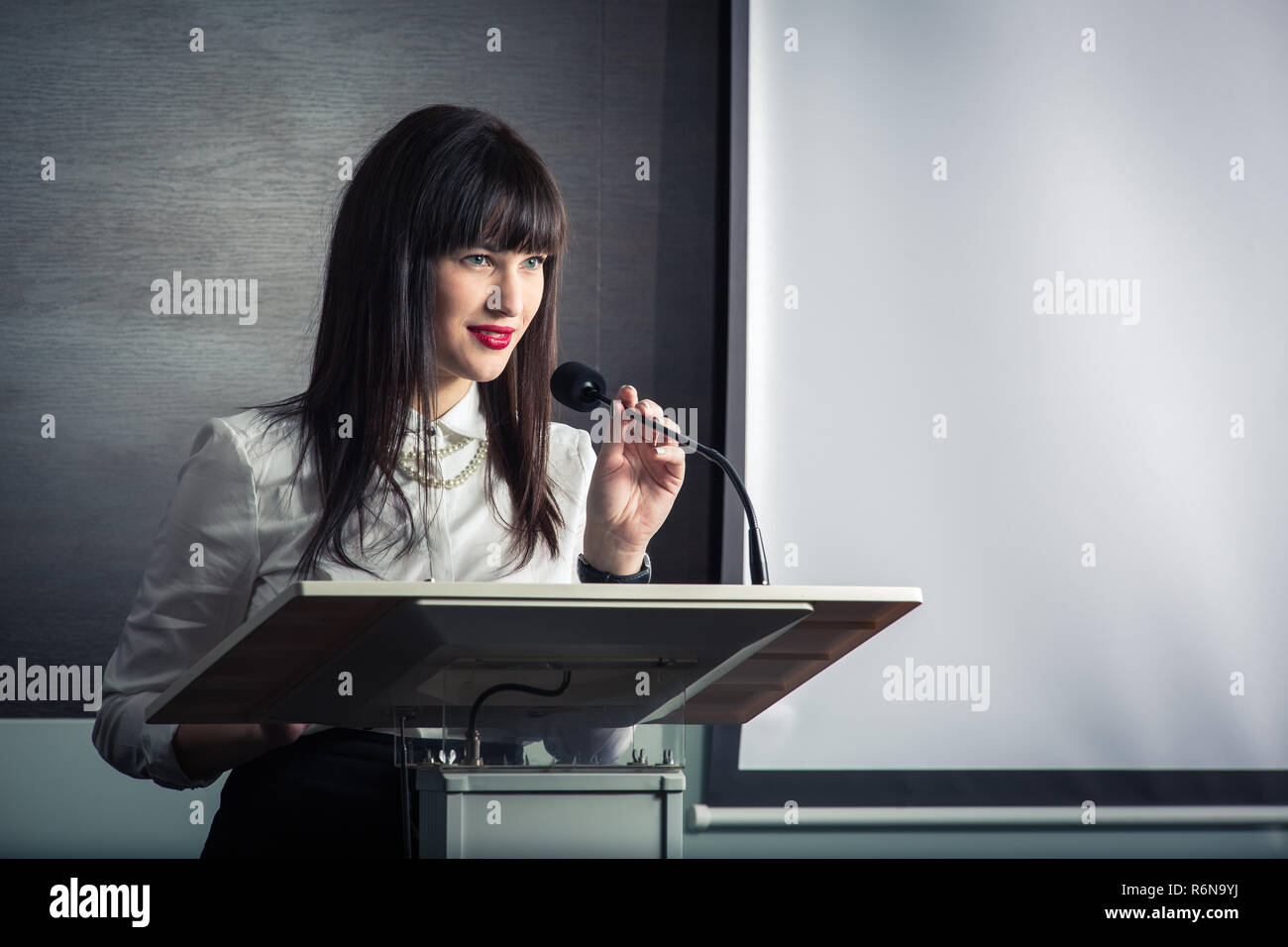 Pretty, young business woman giving a presentation in a conference ...