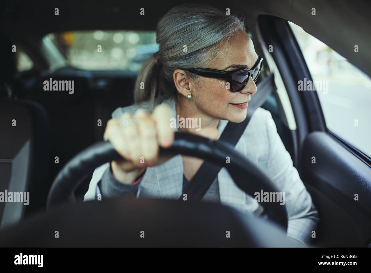 Beautiful senior woman looking away while driving car. Mature ...