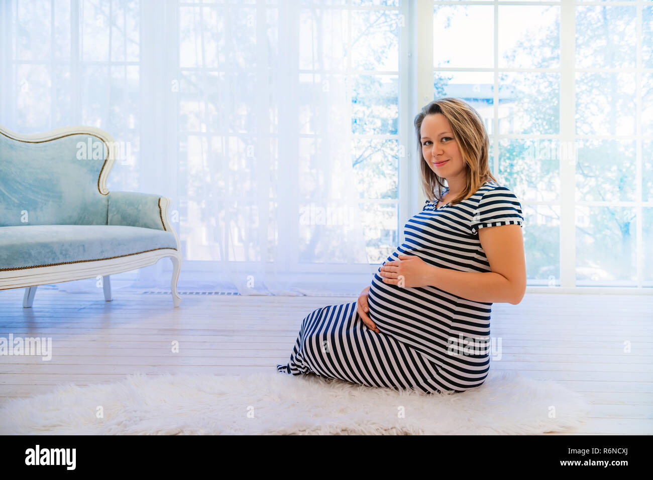 Beautiful pregnant woman sitting near window Stock Photo - Alamy