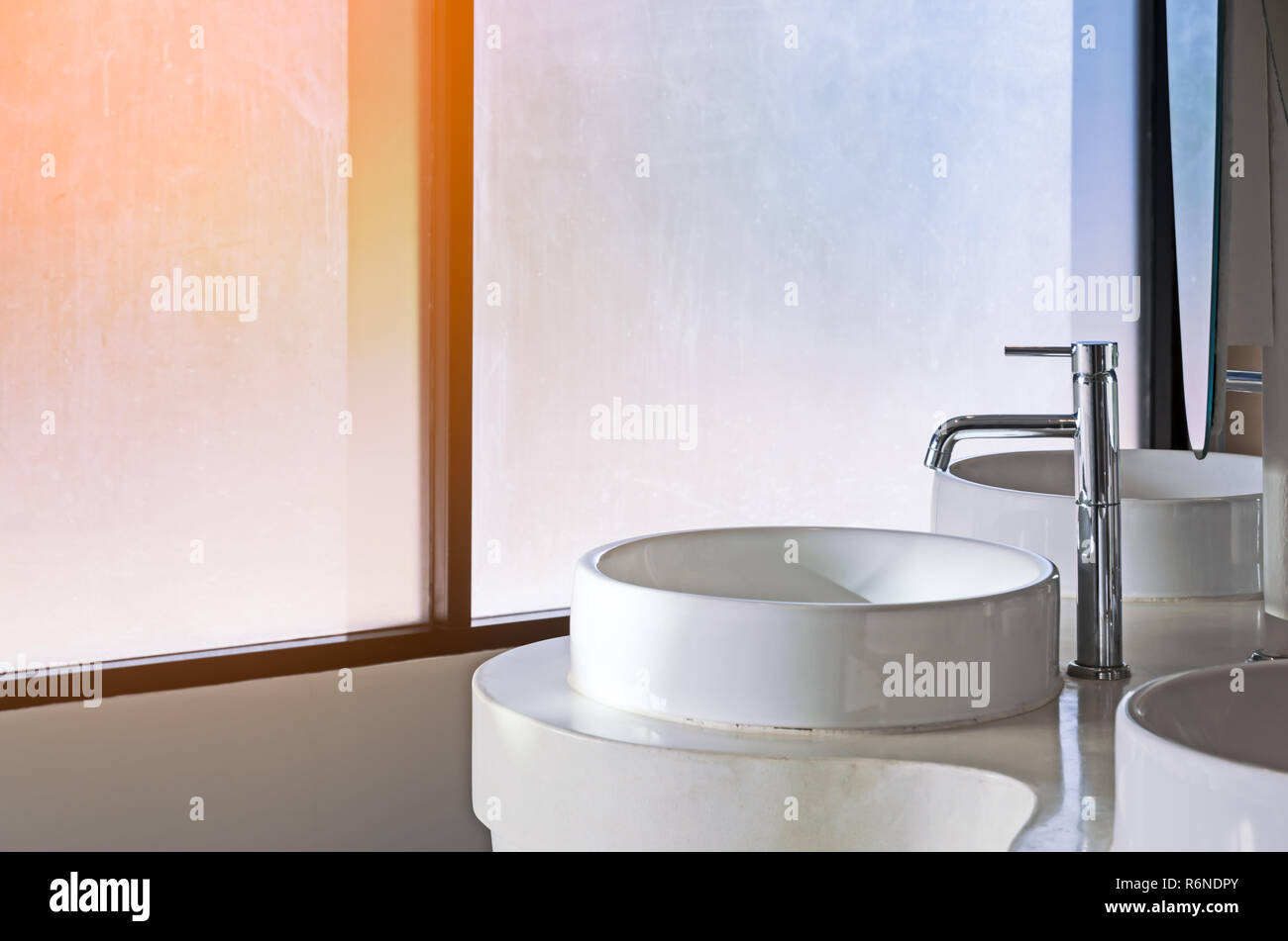 White wash sink basin and faucet in the restroom interior with window ...