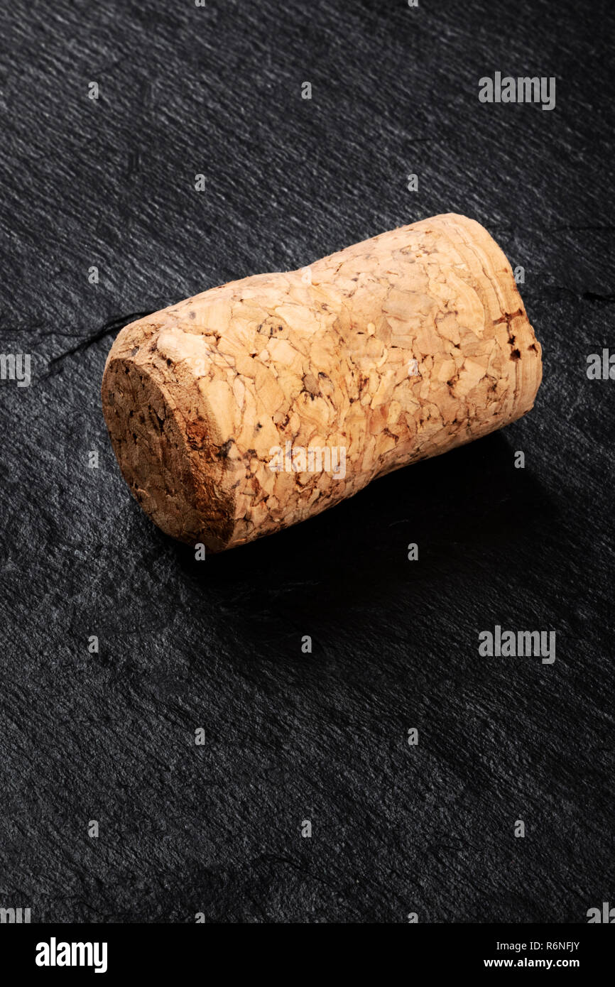 A closeup photo of a champagne cork on a black background with copy ...