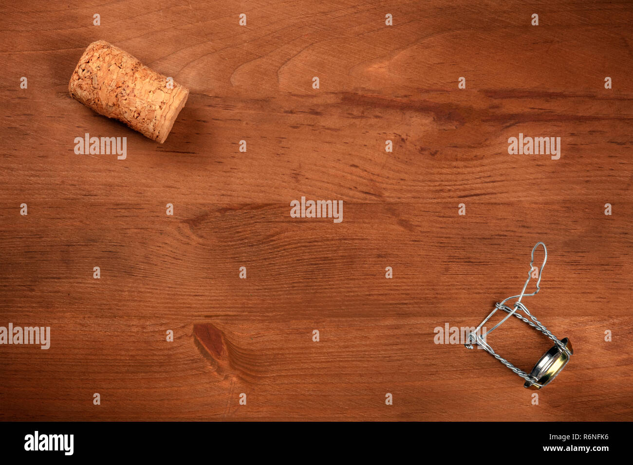A champagne cork and closure, shot from above on a dark rustic wooden ...