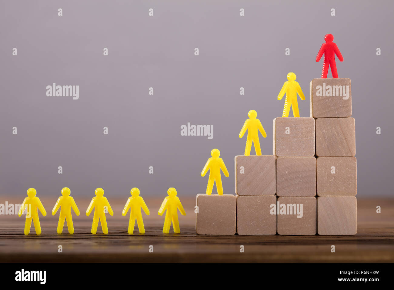 Red Figure Leading Human Figures On Top Of Wooden Blocks Stock Photo ...