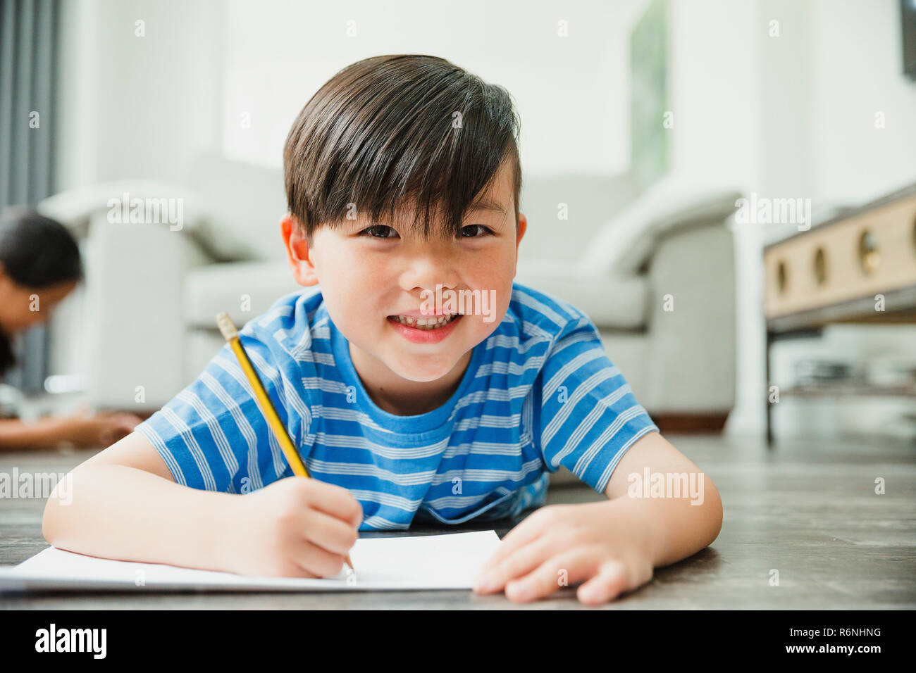Little Boy Doing his Homework on the Floor Stock Photo - Alamy