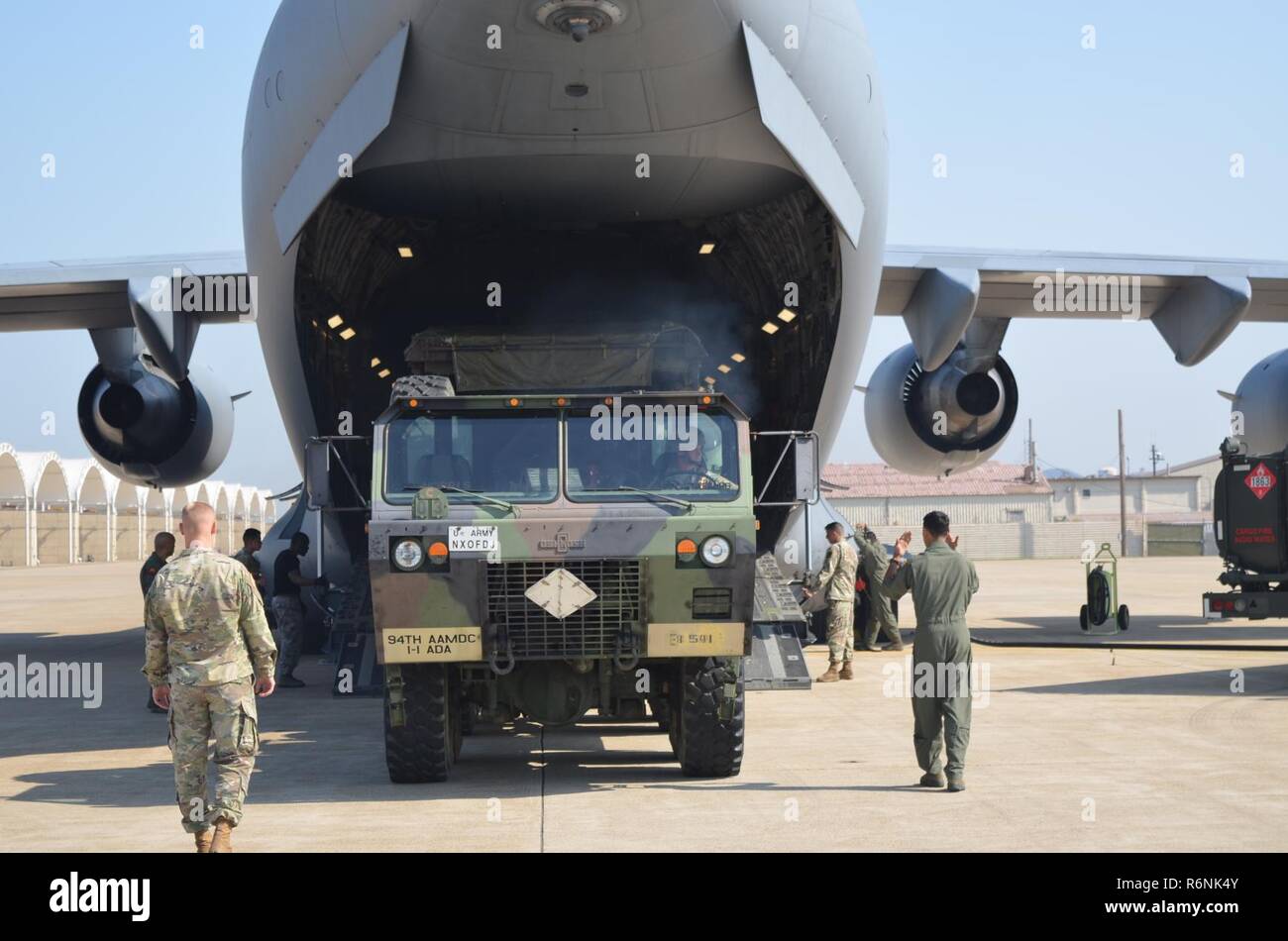 A Soldier and Airman use hand and arm signals to guide a Patriot radar ...