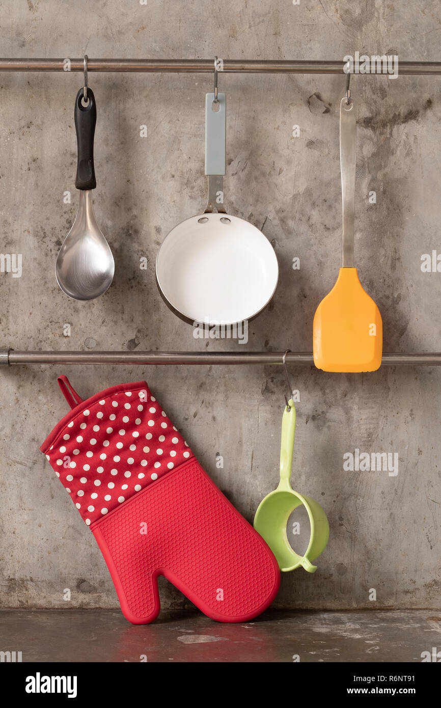Kitchenware hanging on stainless rail on cement wall background Stock ...