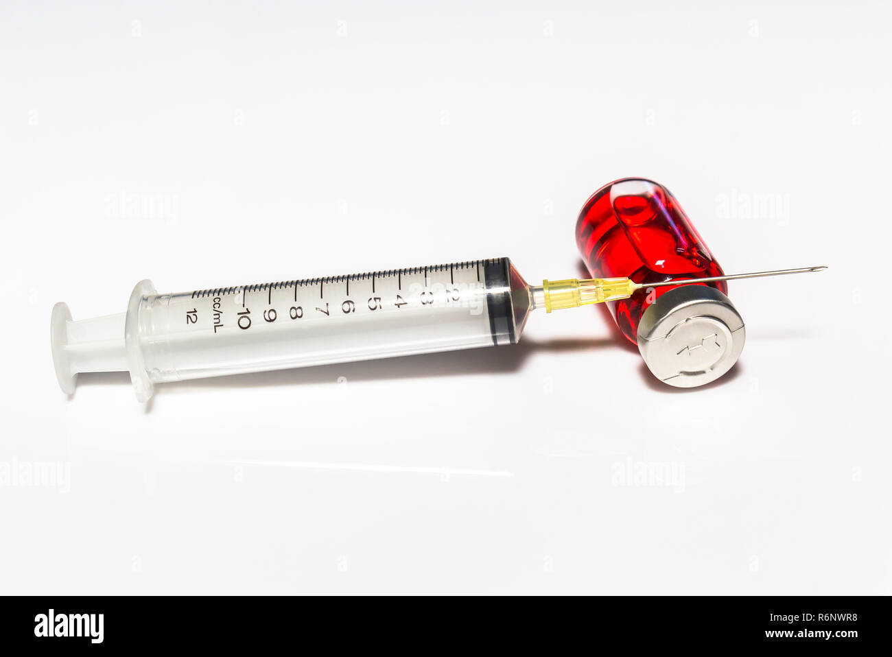 Needle and injection in bottle on white Stock Photo - Alamy