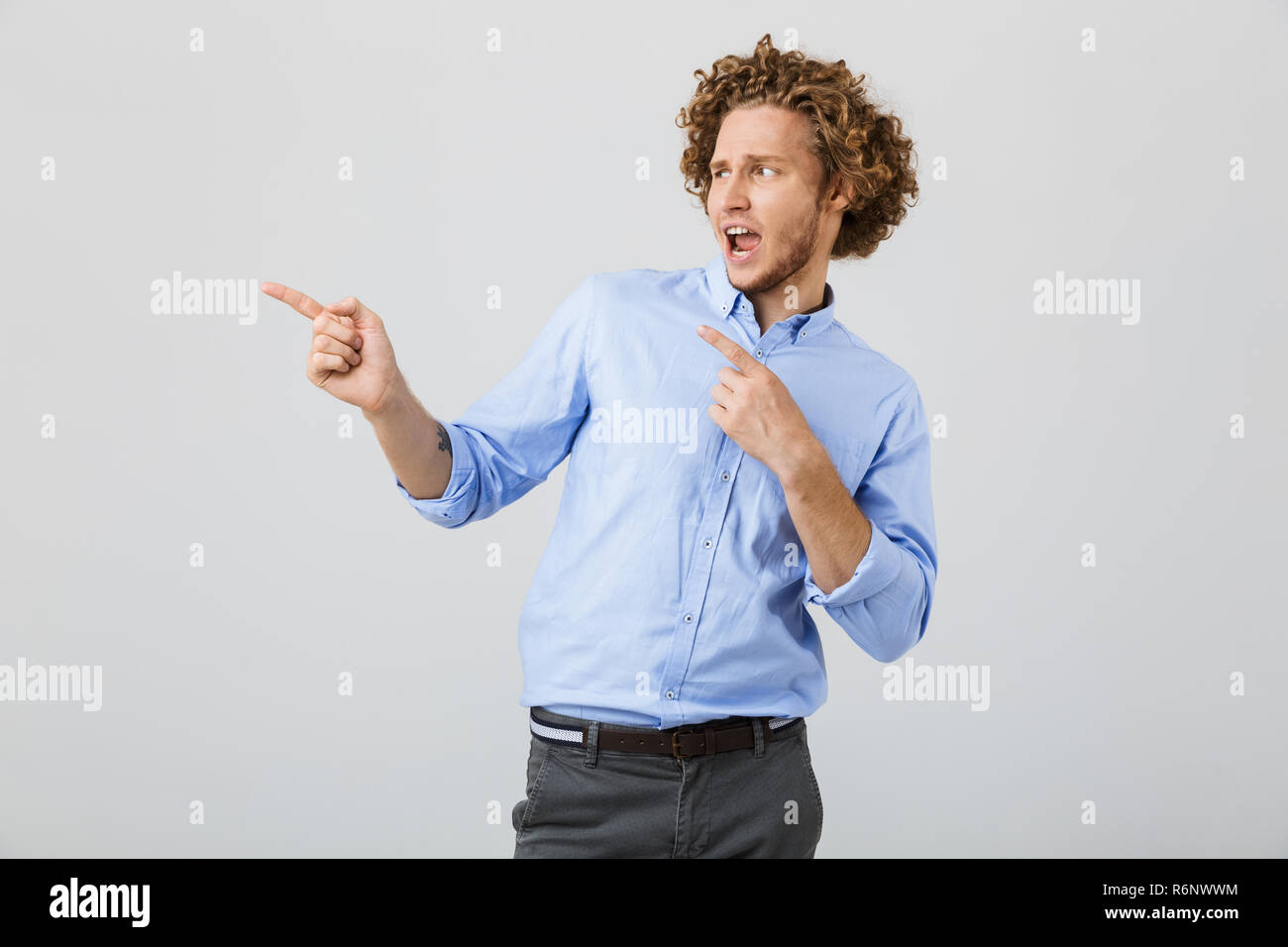 Portrait of a cheerful young man with curly hair isolated over white ...