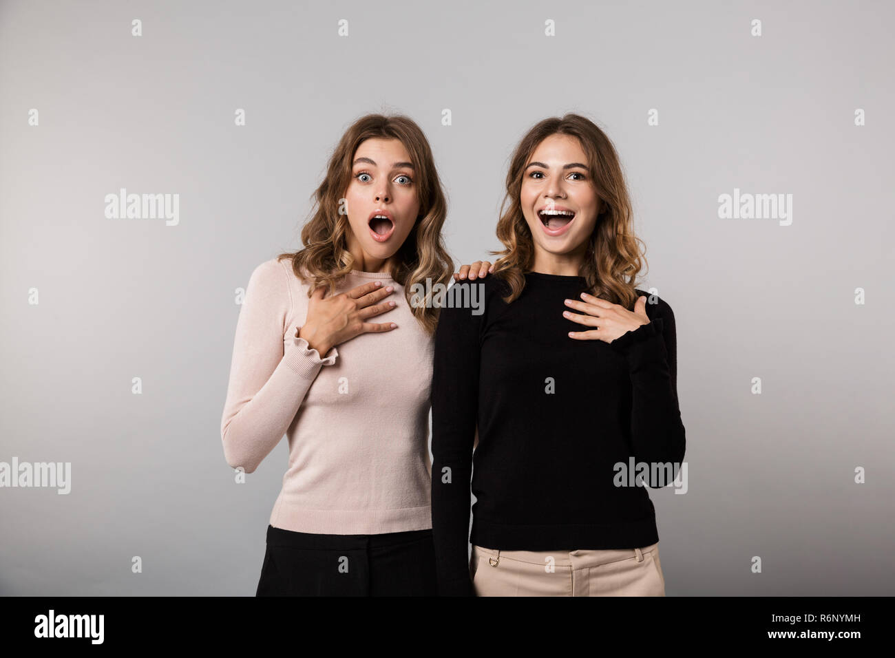 Image of two surprised women wondering while posing together isolated ...