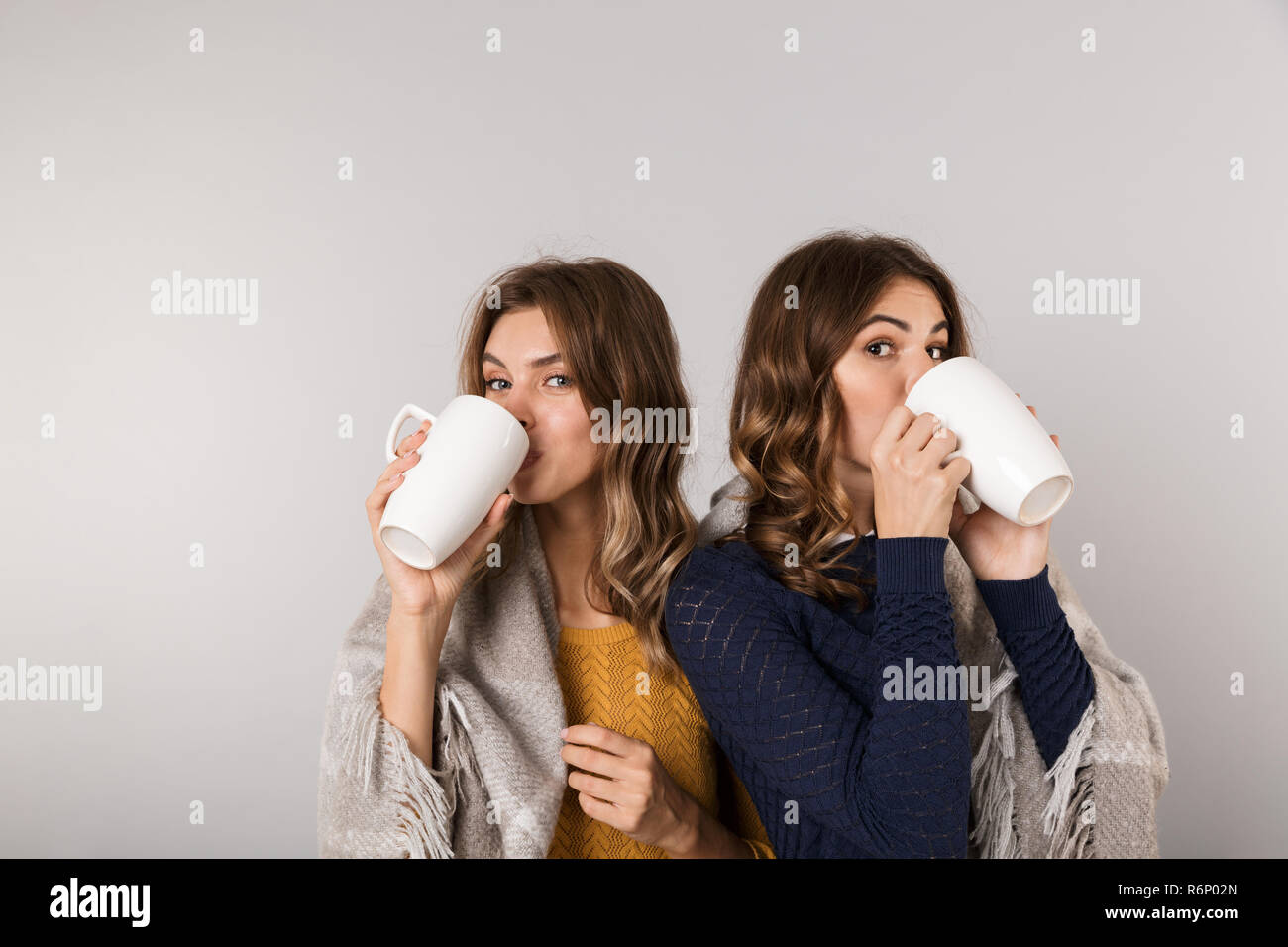 Image of two young women covered with blanket drinking hot tea from ...