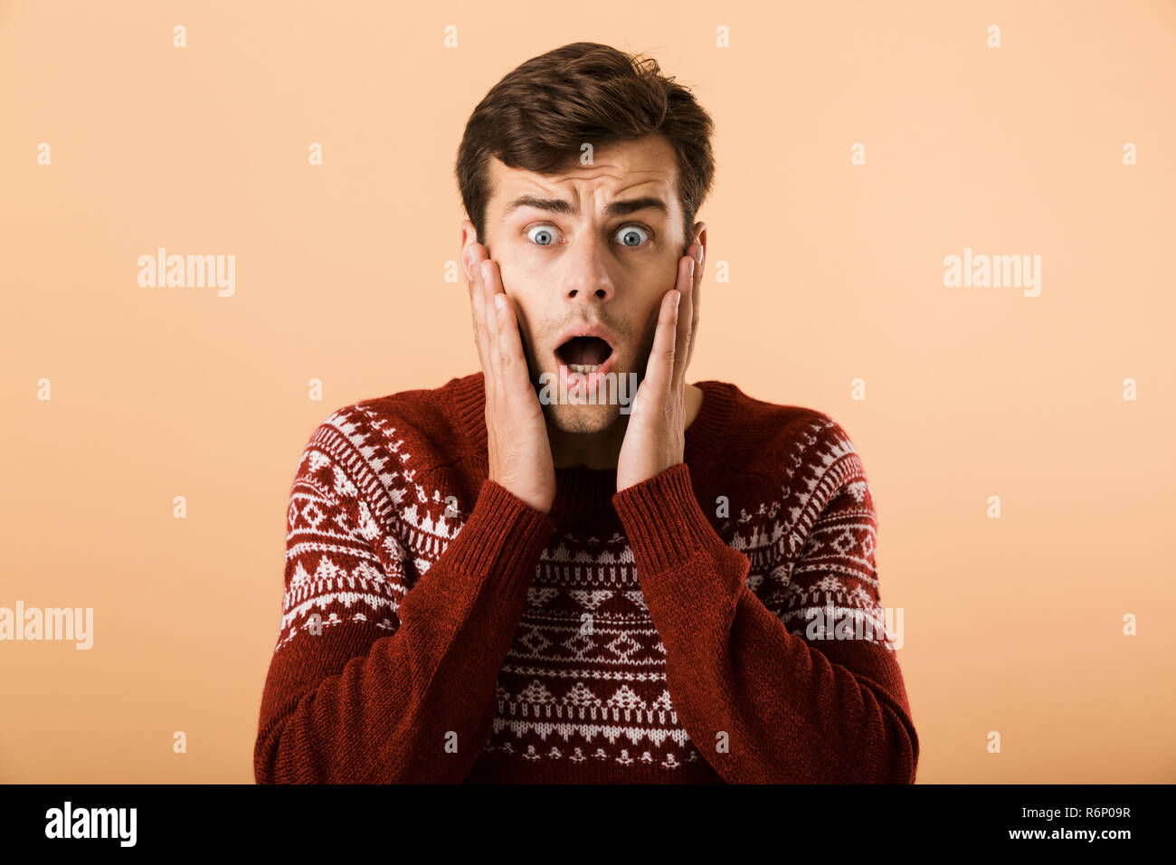 Image of intimidated man 20s with stubble wearing knitted sweater ...