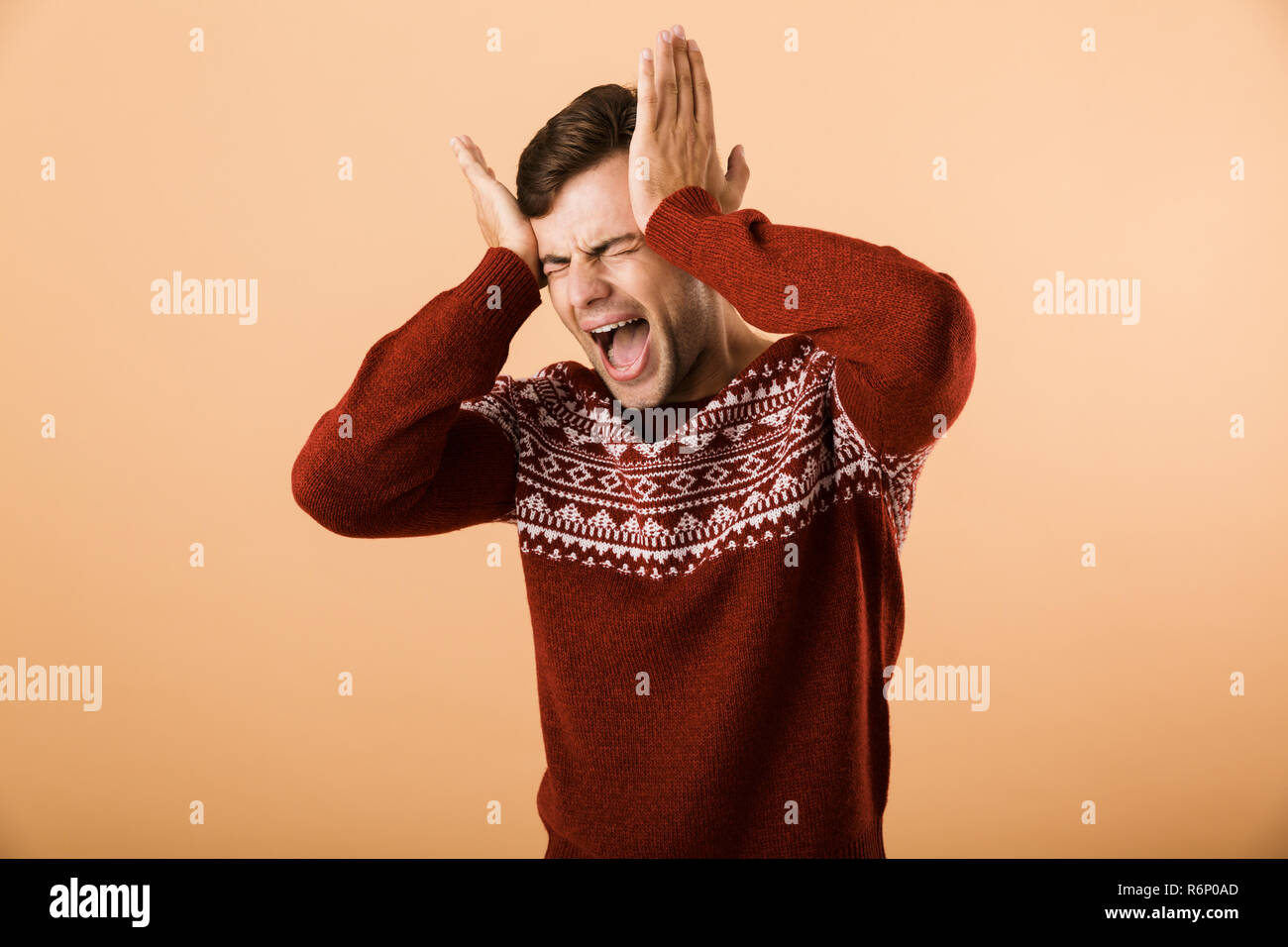 Image of frustrated man 20s with stubble wearing knitted sweater ...