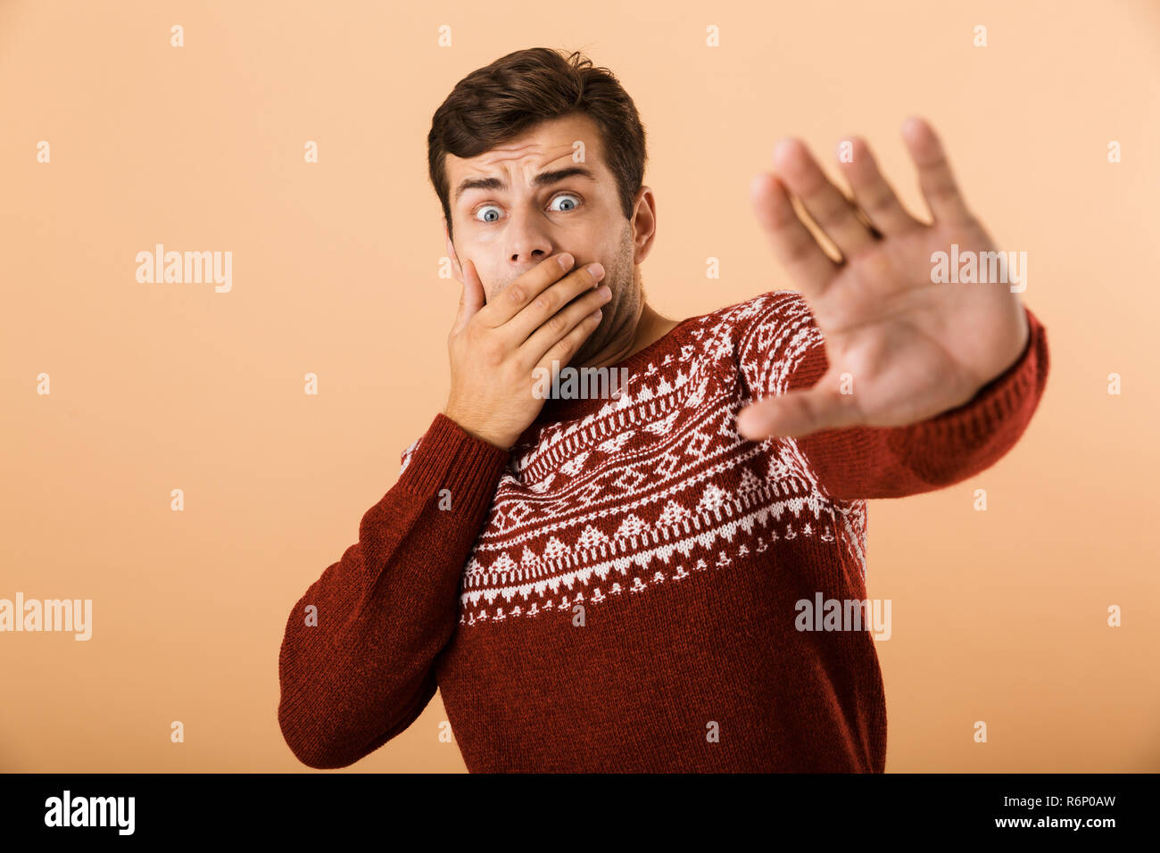 Image of shocked man 20s with stubble wearing knitted sweater doing ...