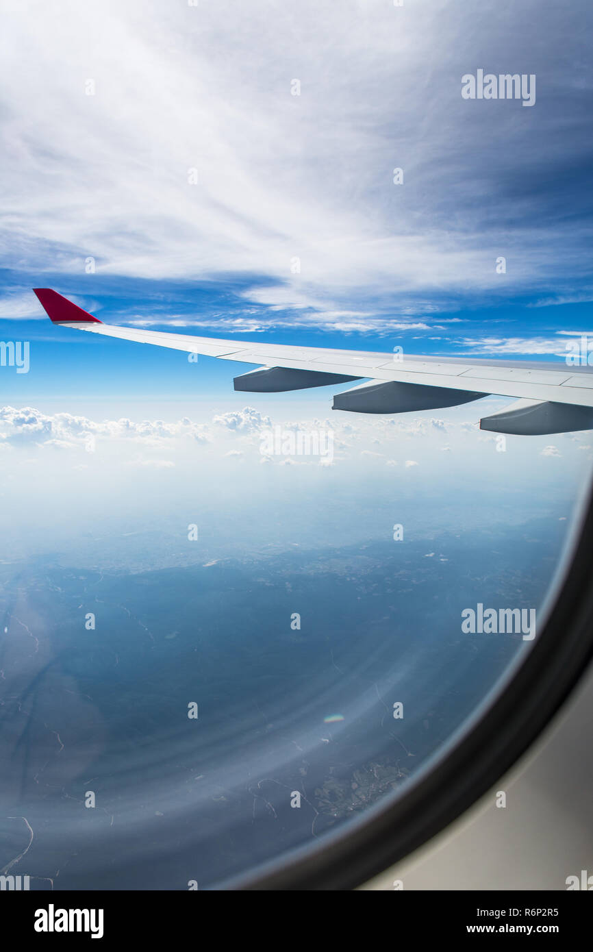 An airplane wing through airplane window with blue sky background Stock ...