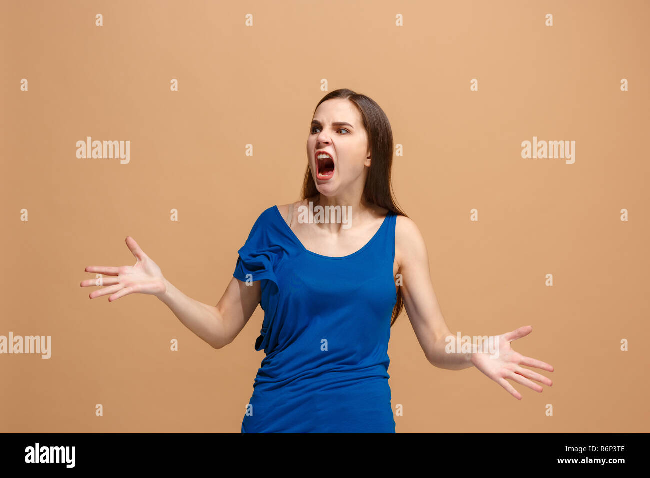 The young emotional angry woman screaming on pastel studio background ...