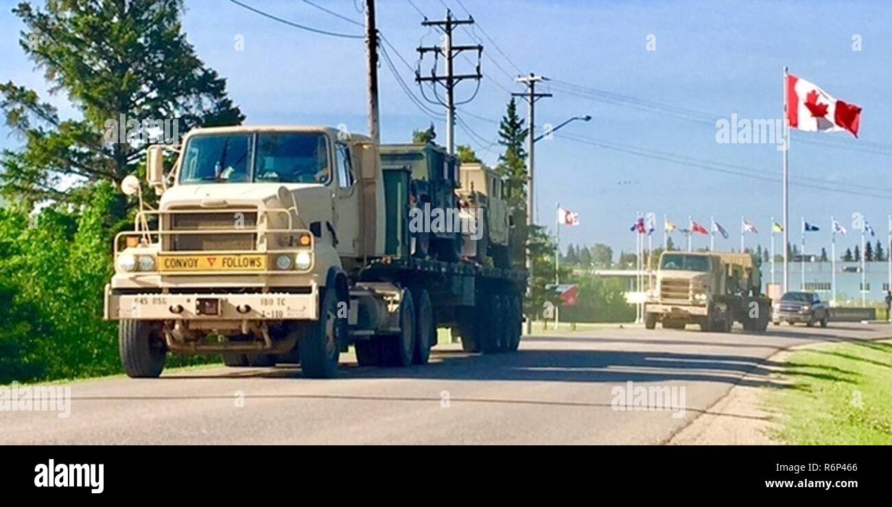 A U.S. Army flatbed truck carries two HMMWVs during an exercise at ...