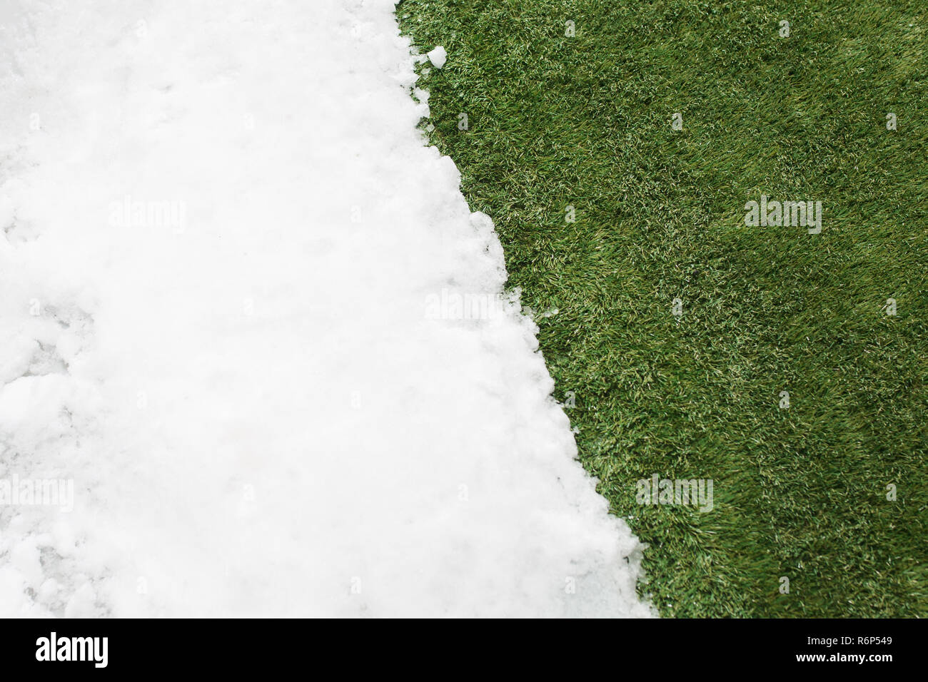 Meeting snow on green grass close up - between winter and spring ...