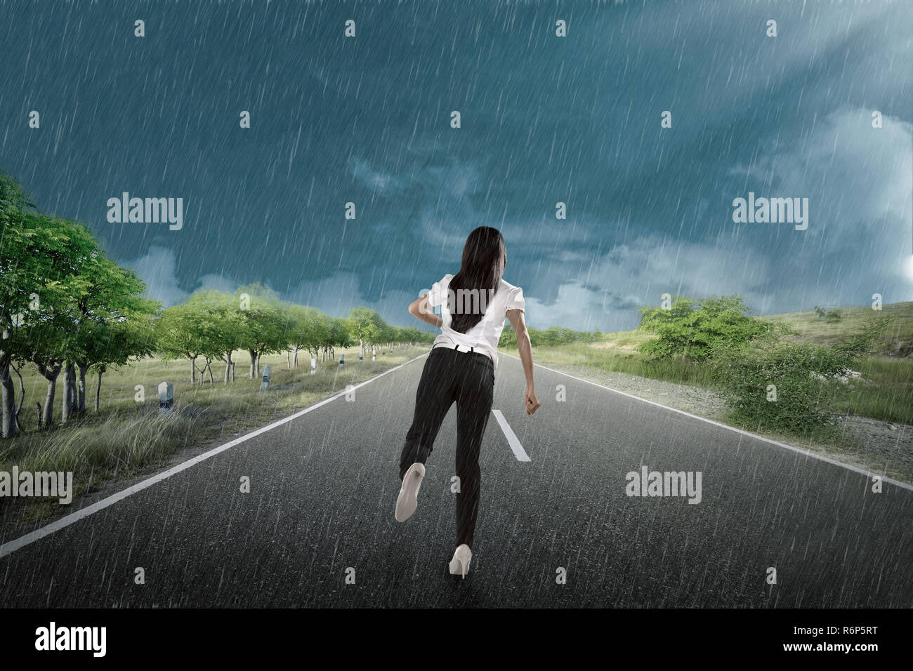 Businesswoman is moving forward under the rain Stock Photo - Alamy