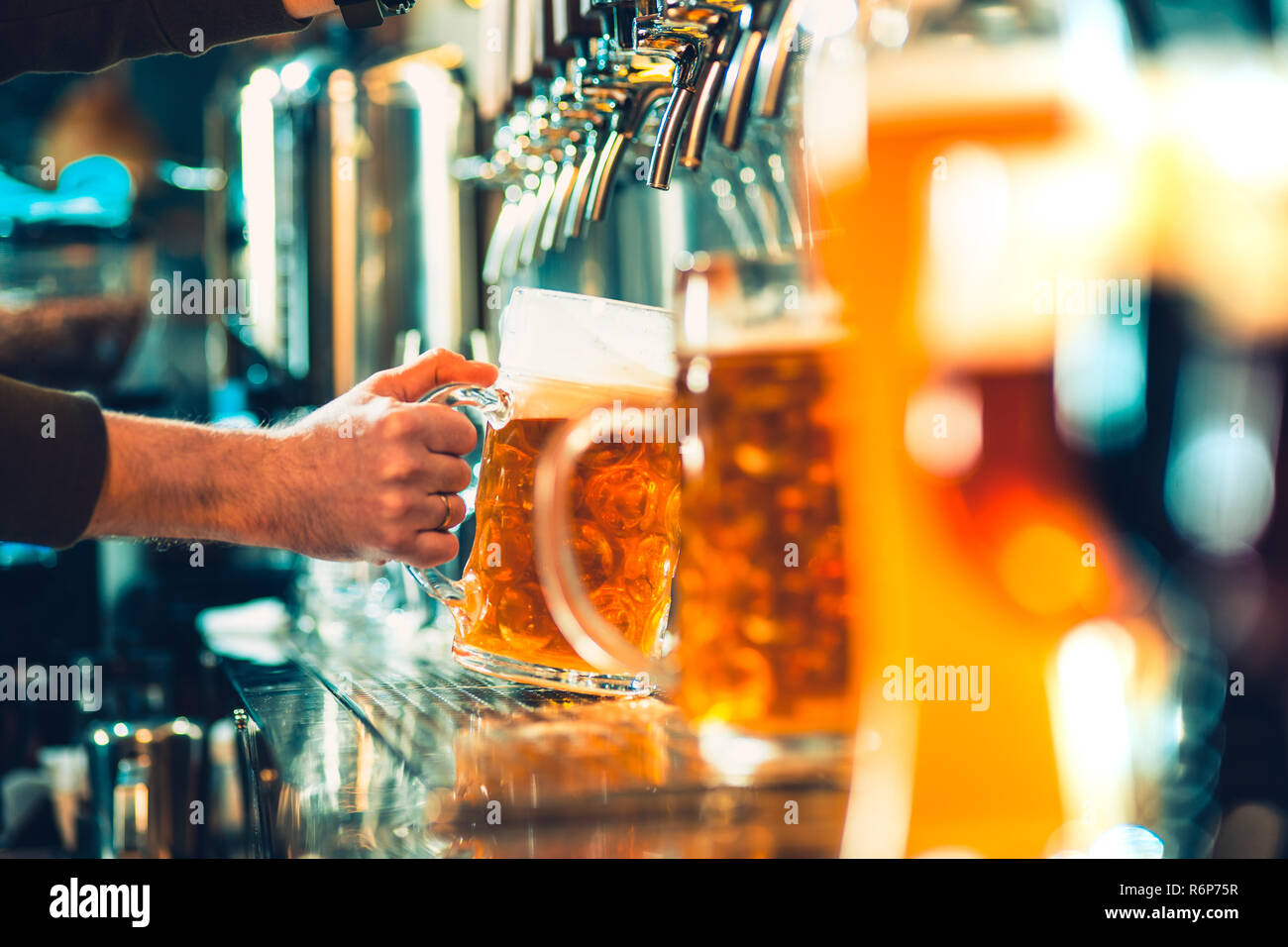 Hand of bartender pouring a large lager beer in tap Stock Photo - Alamy