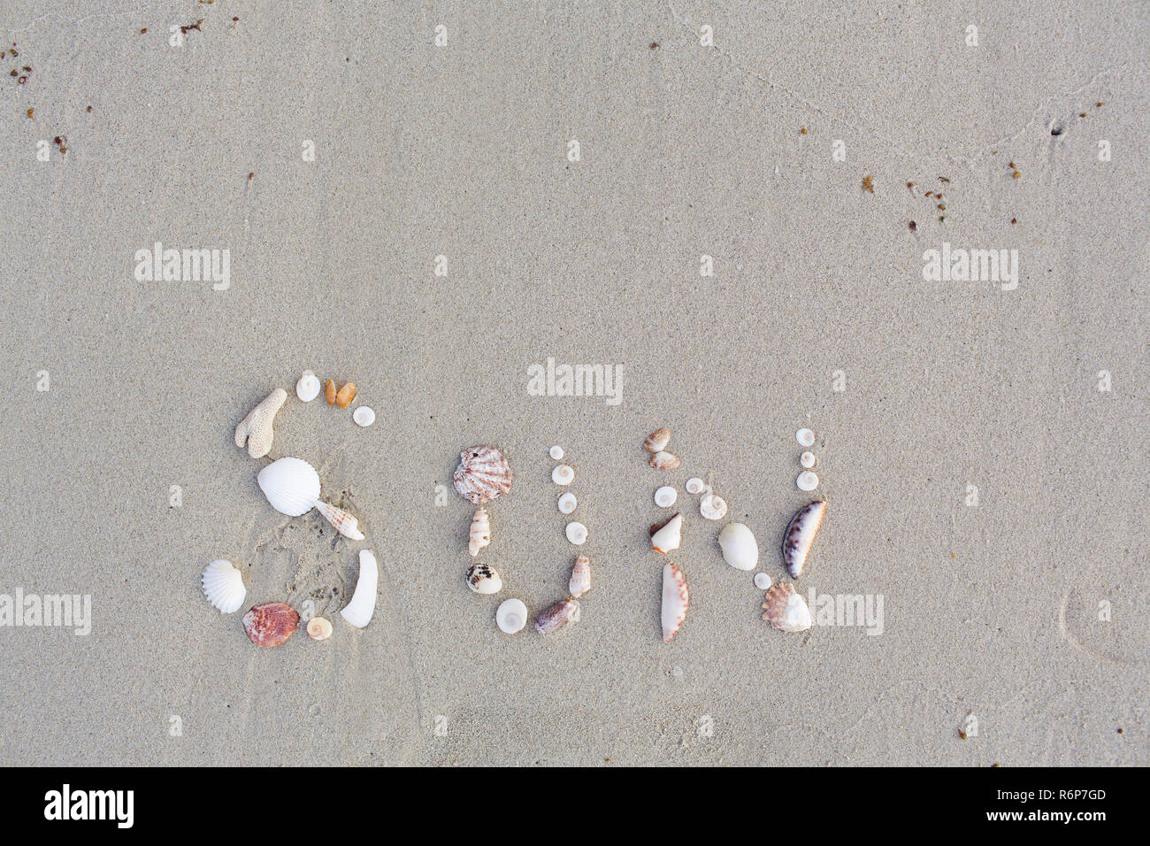 the word sun,written with shells in the sand Stock Photo - Alamy