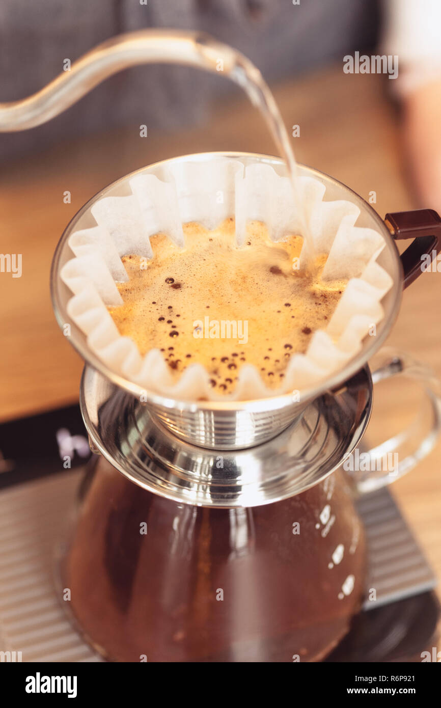 Hand drip coffee, Barista pouring water on coffee ground with filter ...