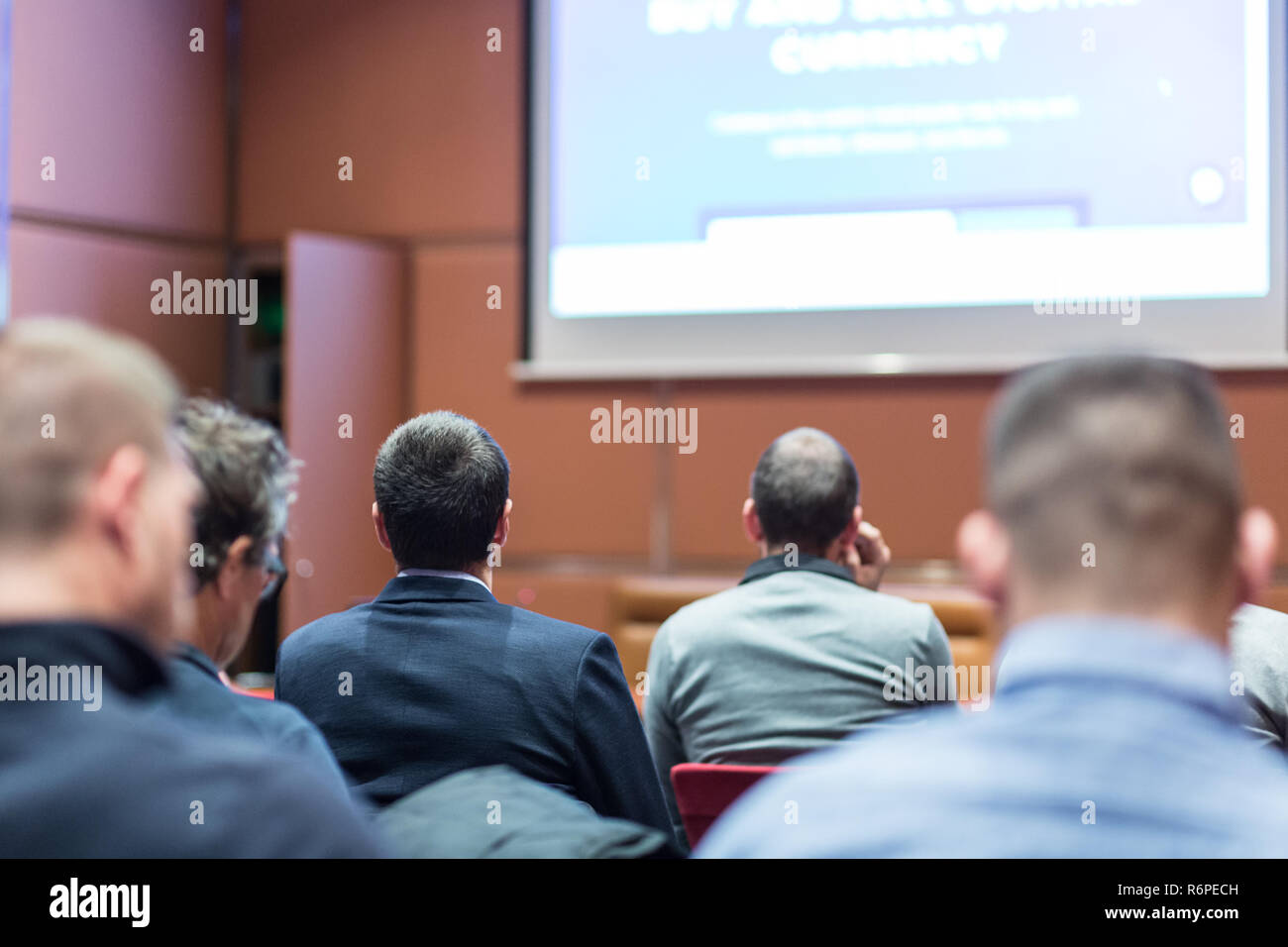 Audience in conference hall listening to presentation on business ...