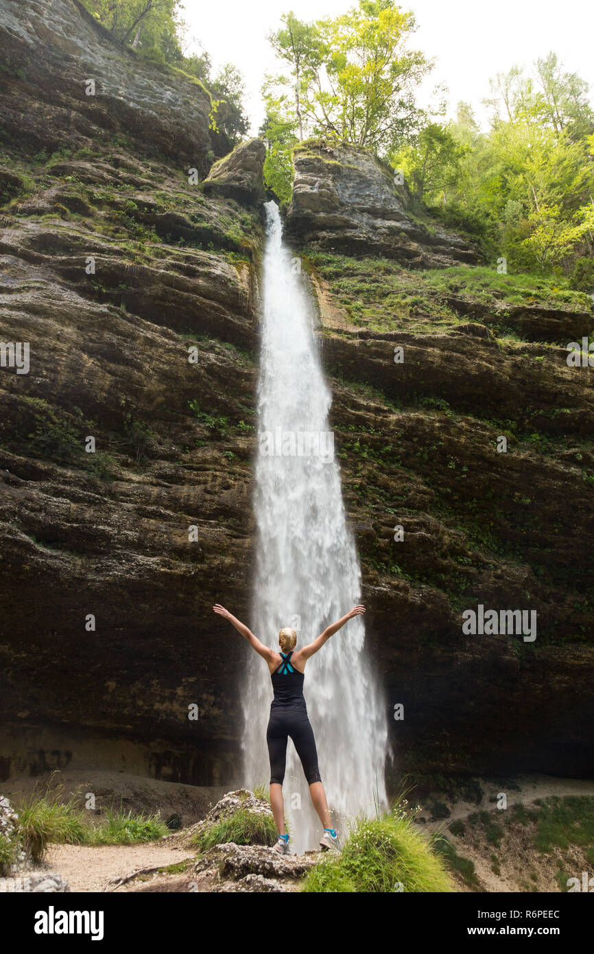 Active woman raising arms inhaling fresh air, feeling relaxed in nature ...