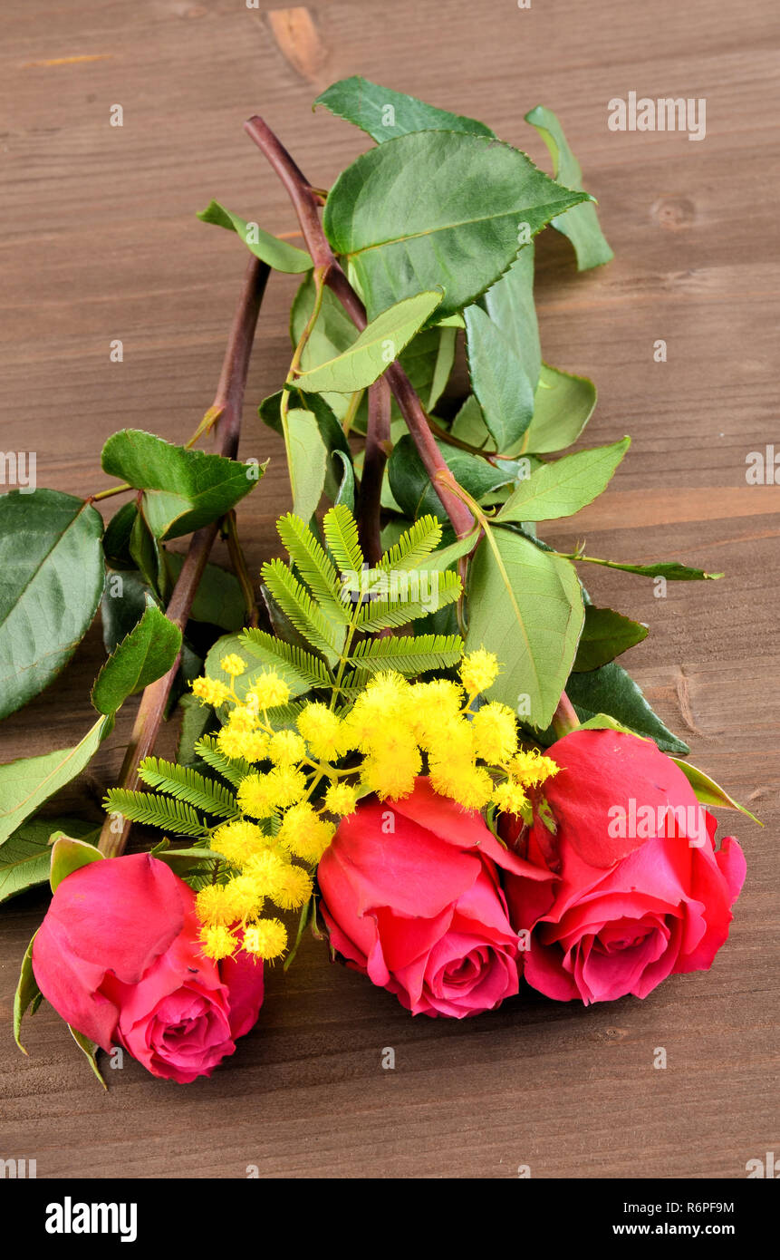 Three red roses against a brown background Stock Photo - Alamy